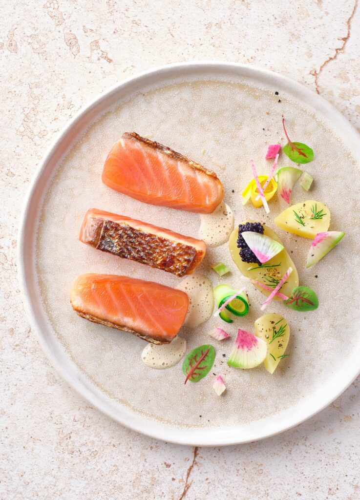 Crispy smoked salmon ventrèche, steamed potatoes, and radish condiment ...